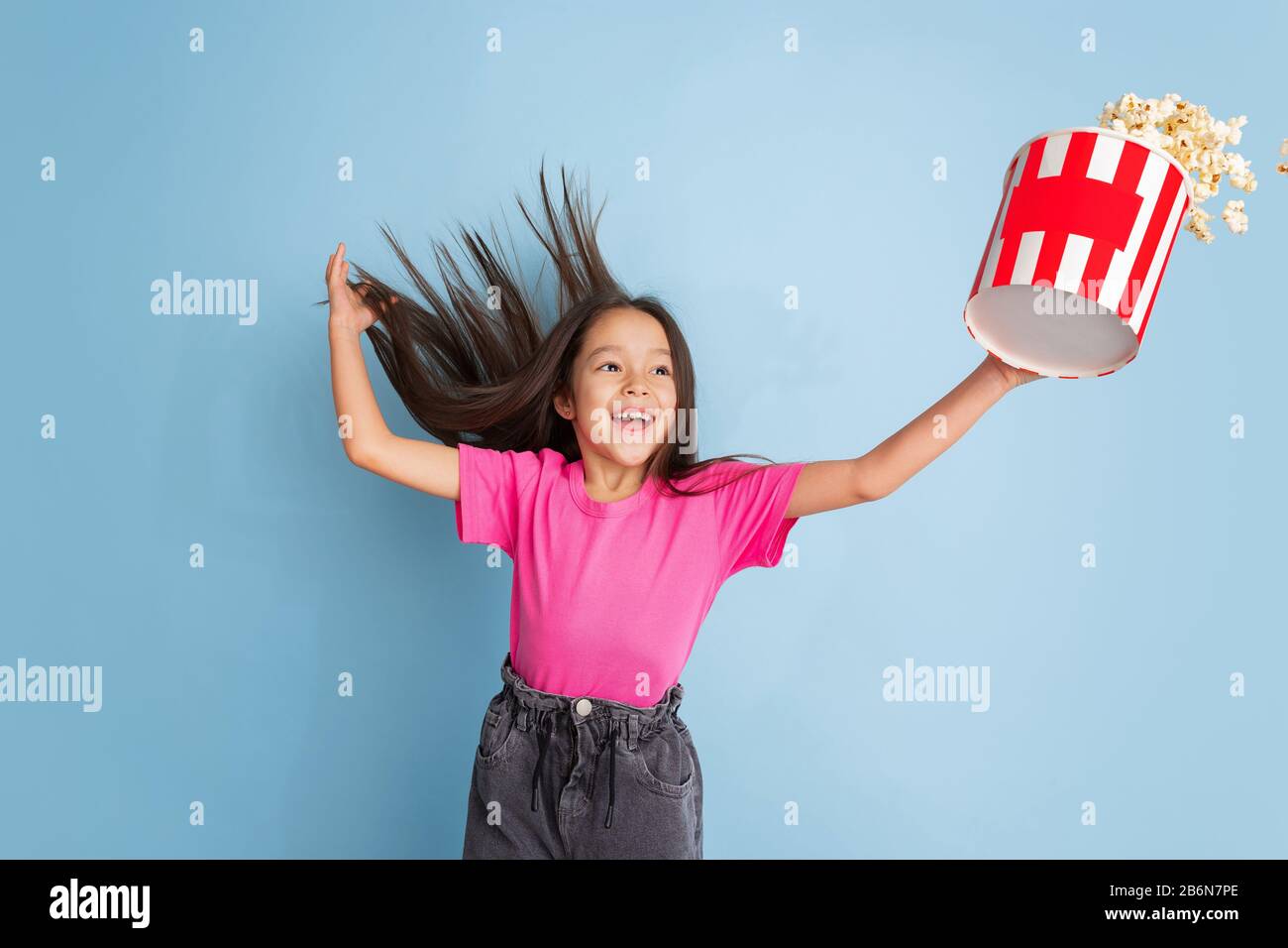 Watching cinema, shocked, flying popcorn. Caucasian little girl's ...