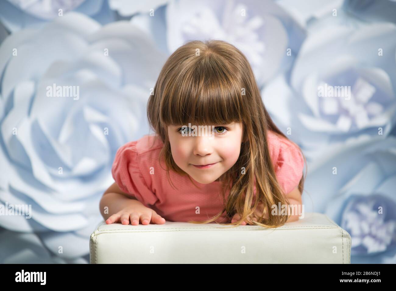 Little girl portrait on a paper flower background, decorative flower ...