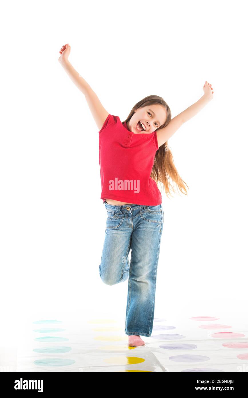 Happy child posing in childrens clothes standing on one leg, arms ...