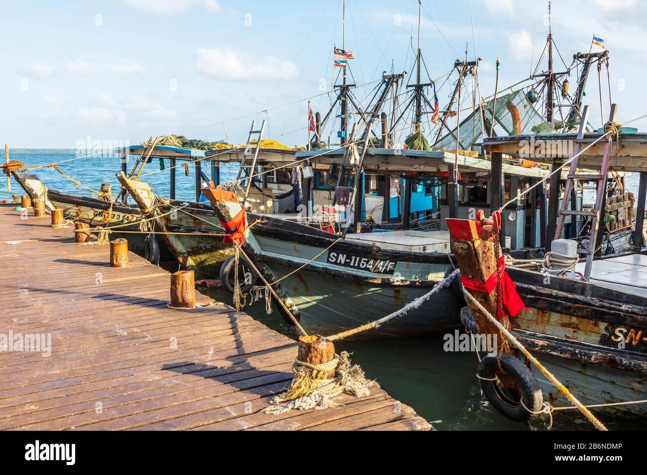 Fishing boats and fishermen in the harbour at Sandakan, Sabah District ...