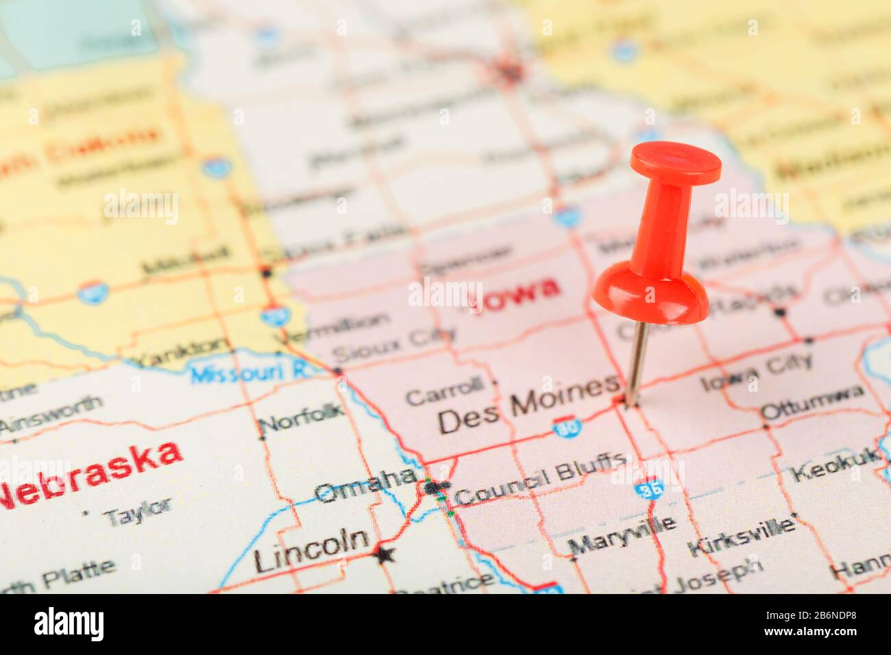 Red clerical needle on a map of USA, Iowa and the capital Des Moines ...