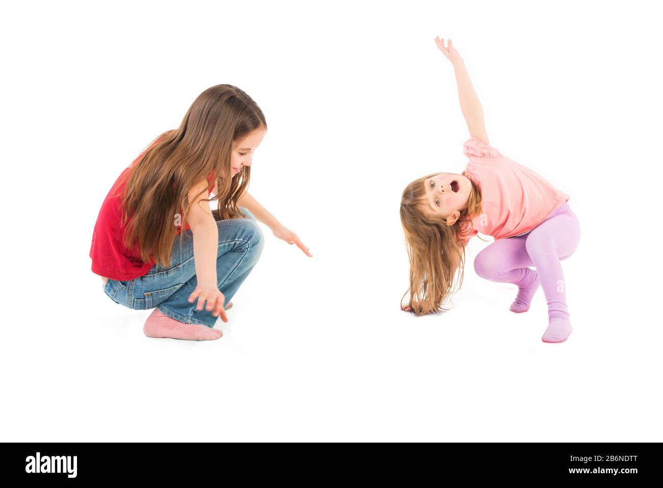 Two happy girls in children's clothes enthusiastically play a game. A ...