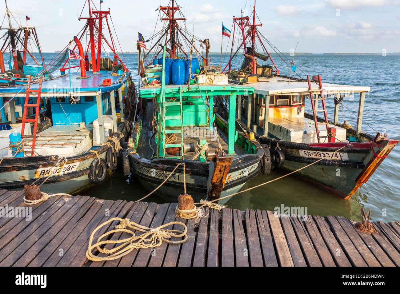 Fishing boats and fishermen in the harbour at Sandakan, Sabah District ...