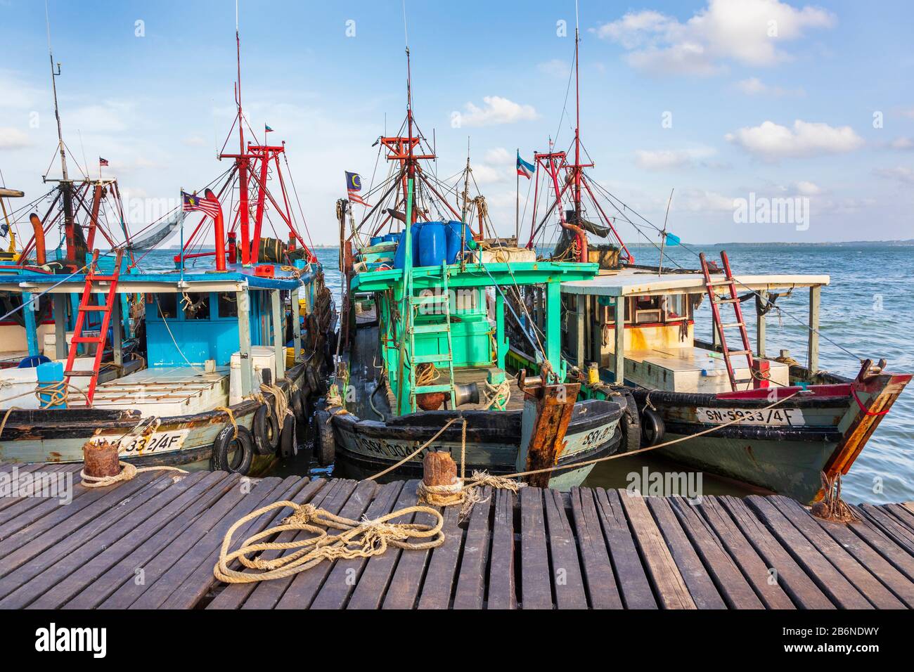 Fishing boats and fishermen in the harbour at Sandakan, Sabah District ...