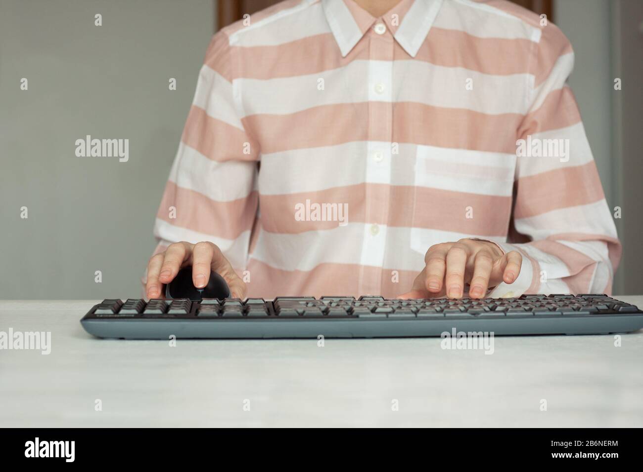 Close-up of hand woman using a mouse and typing on keyboard computer on ...