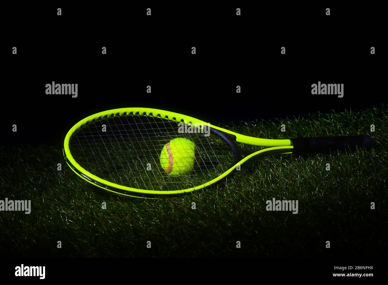 Green tennis racket with tennis balls in green color on grass with ...