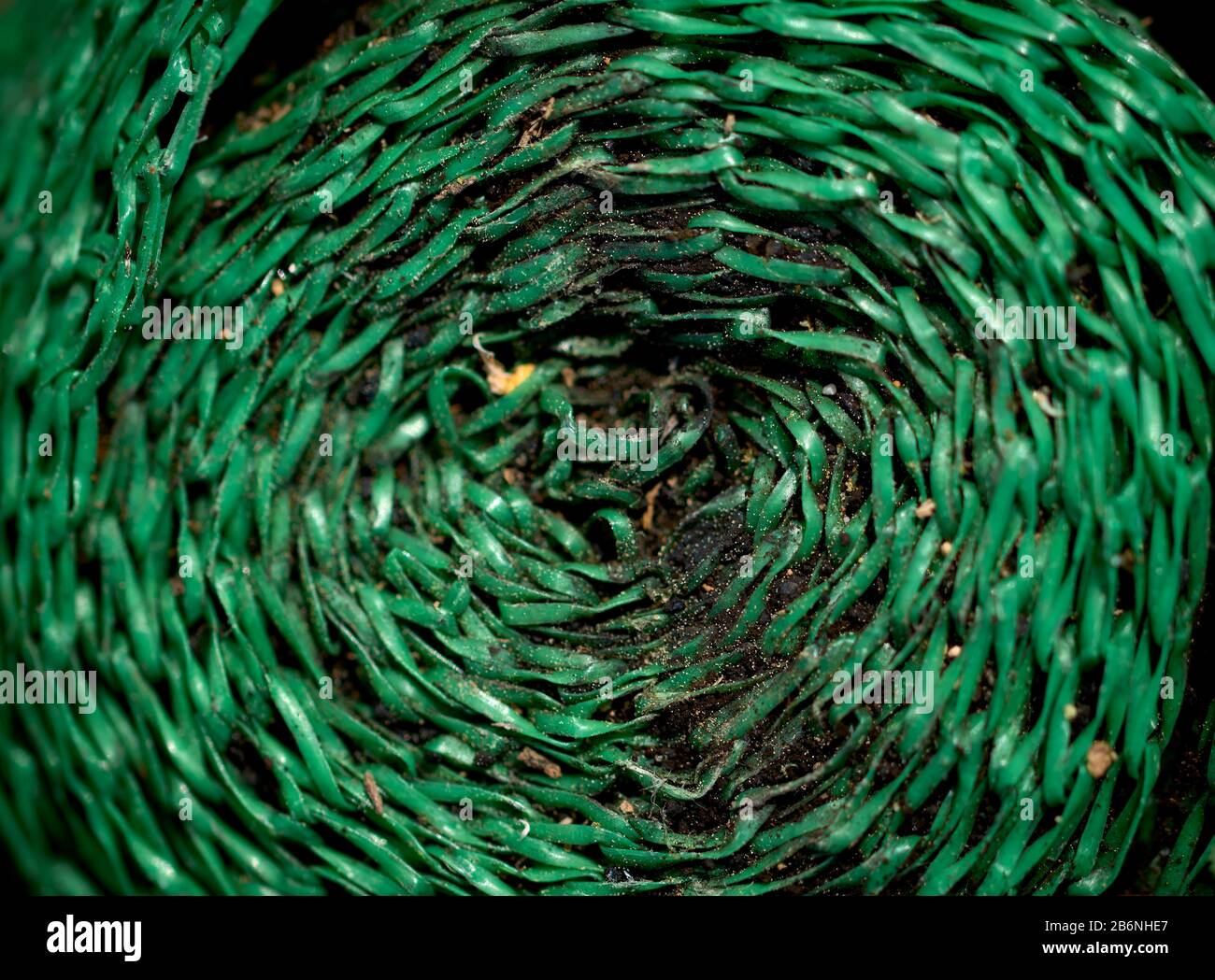 detail of a messy and coiled green piece of plastic messy and abandoned ...