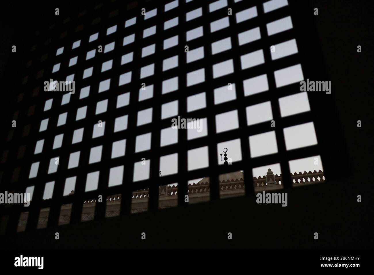 Crescent on mosque dome seen through square lattice window Stock Photo ...