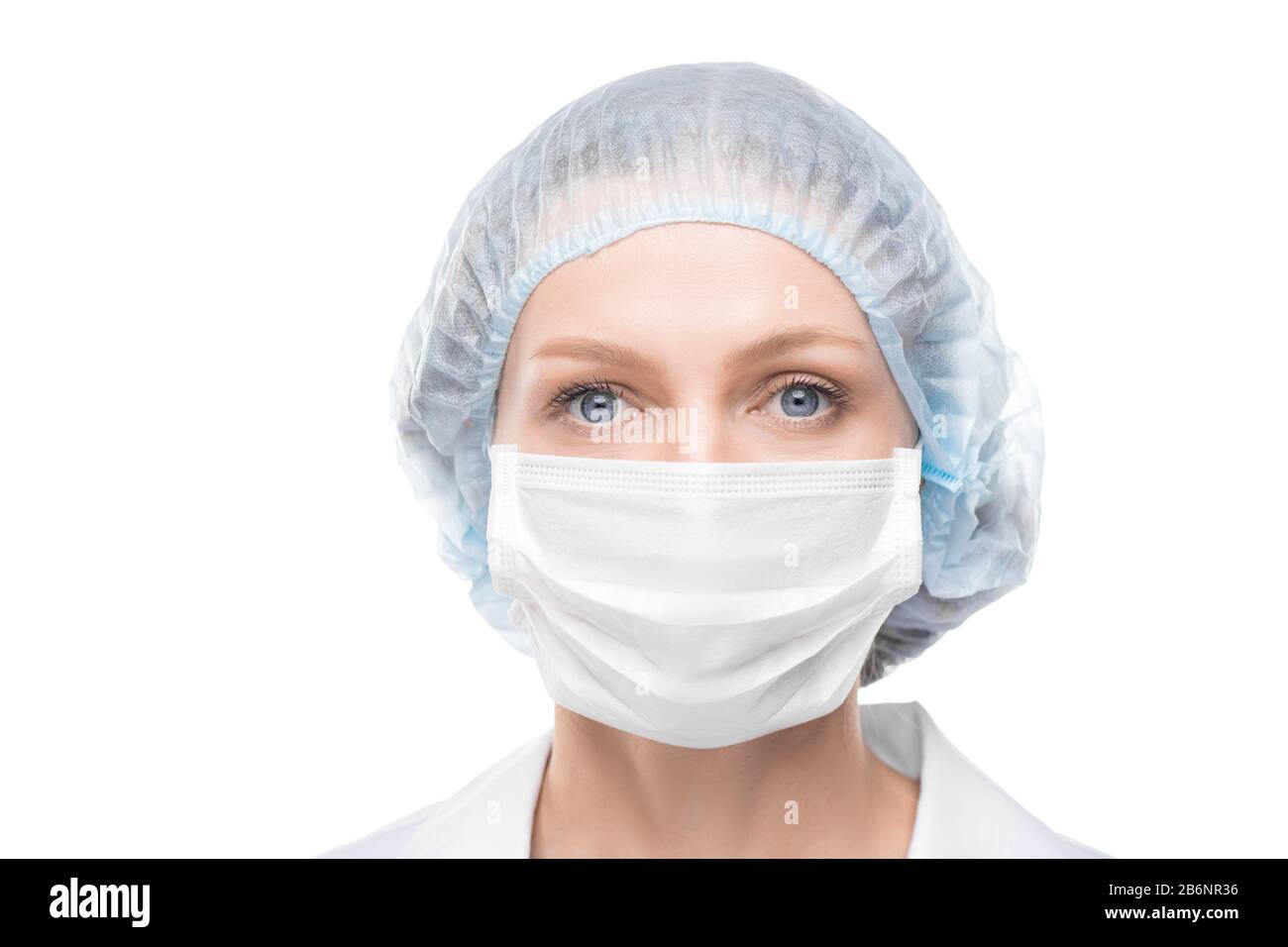 Portrait of lady doctor with blue eyes wearing face mask and surgical ...