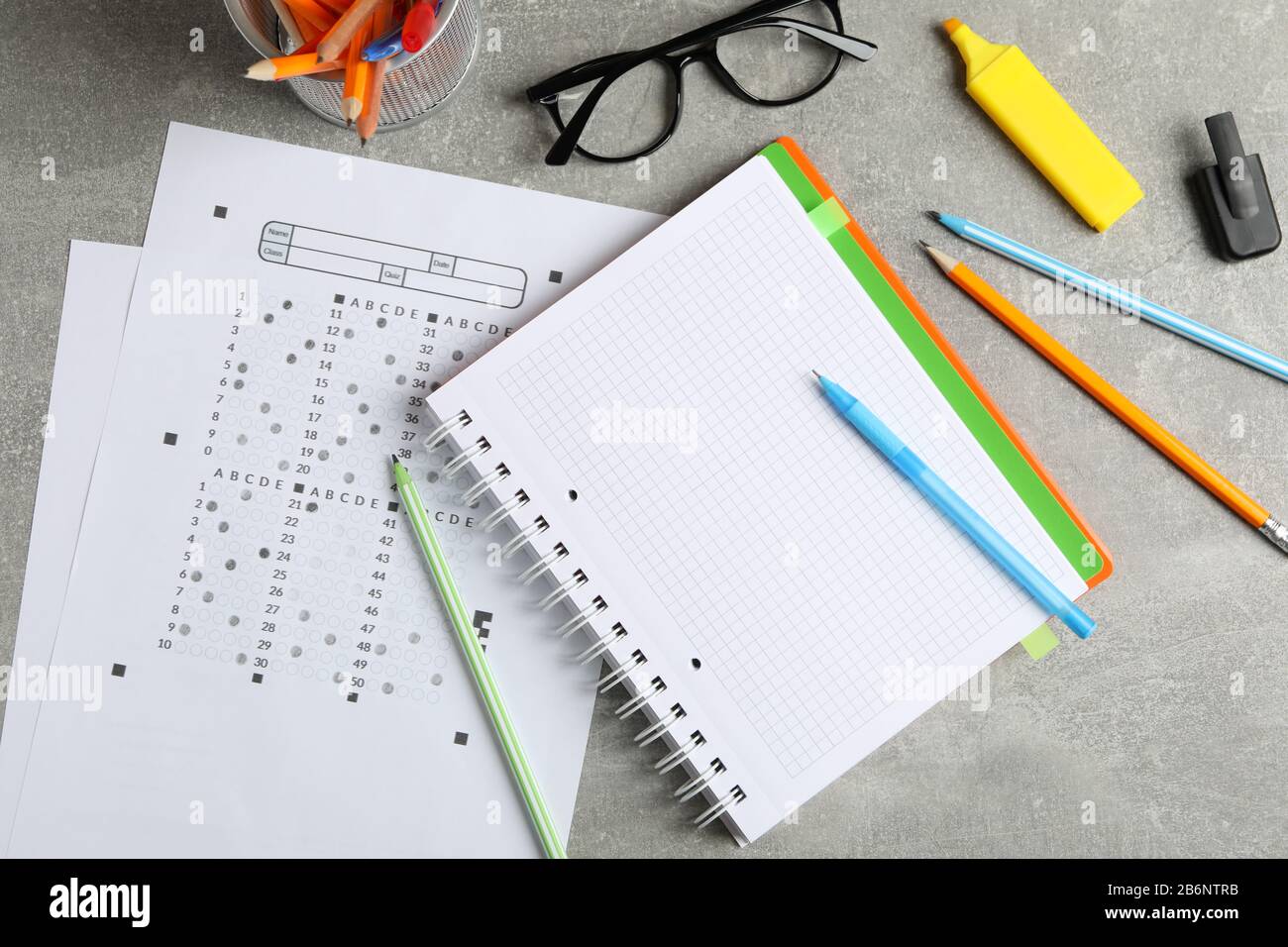 Test sheets, copybook, glasses and stationary on grey background, top ...