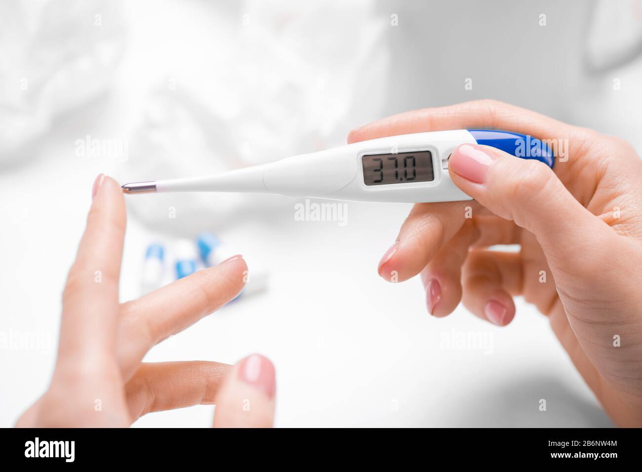 Close-up of unrecognizable woman checking body temperature on digital ...