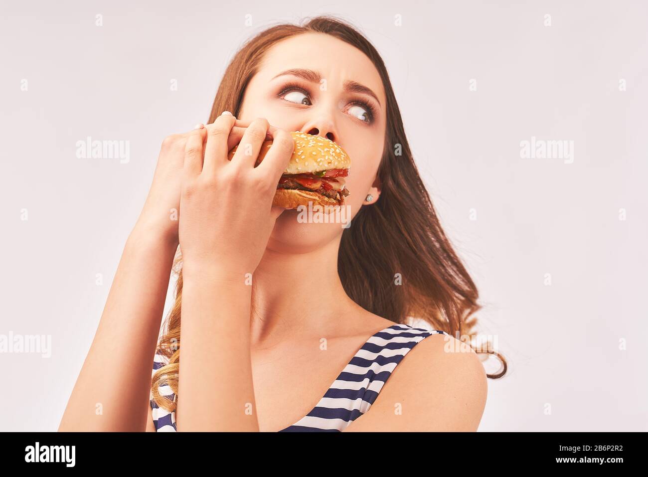 girl quickly eats Burger, afraid of being caught Stock Photo - Alamy