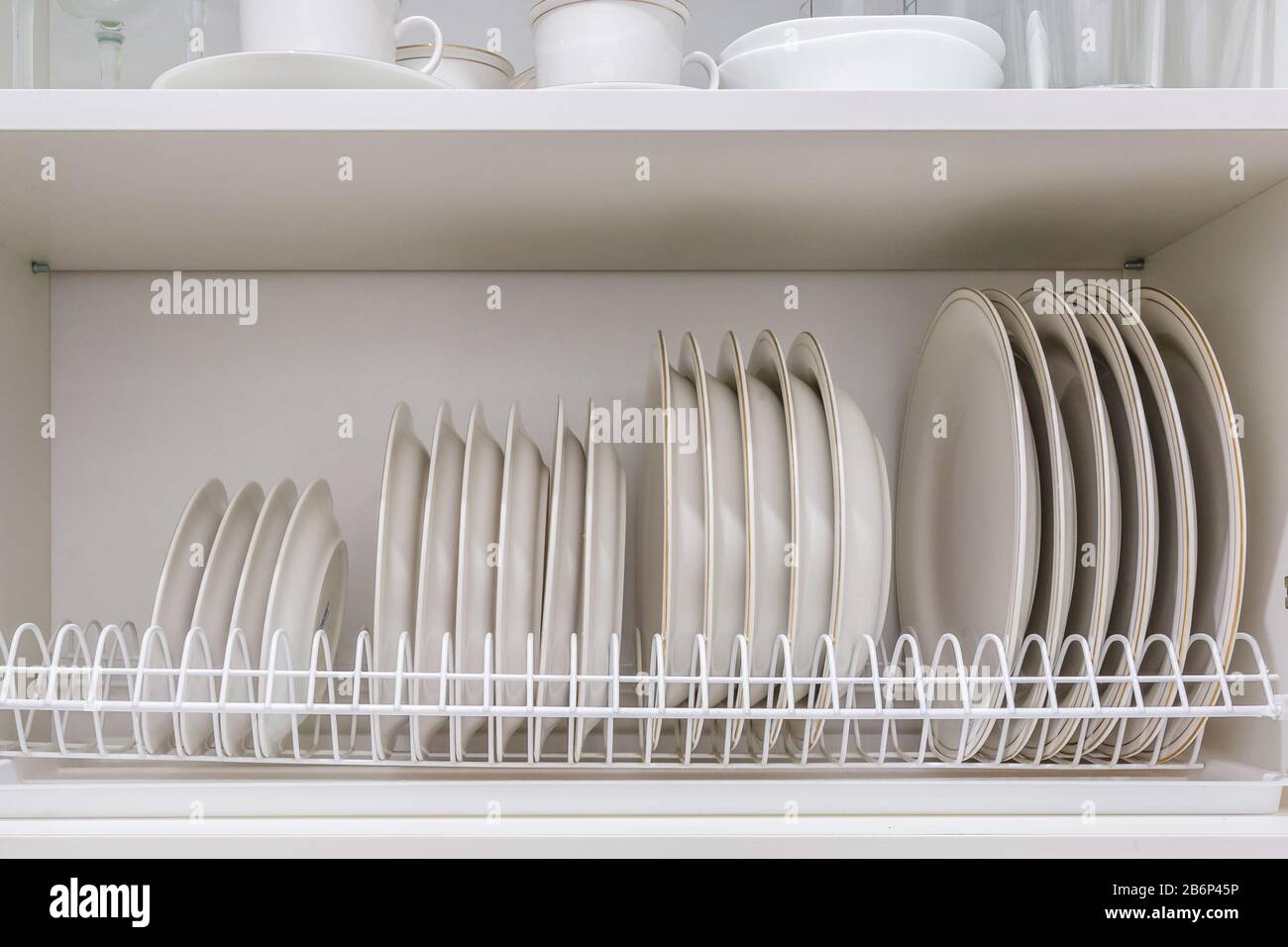 set of plates on the shelf in the kitchen cabinet Stock Photo - Alamy