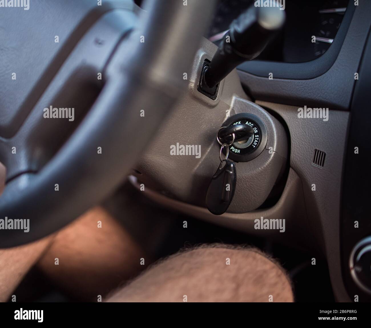 transportation and ownership concept - car key in ignition start lock ...