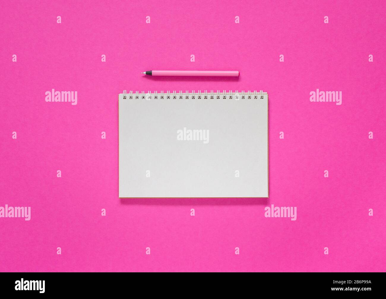 Open spiral notepad on on a bright pink background , notebook and pen ...