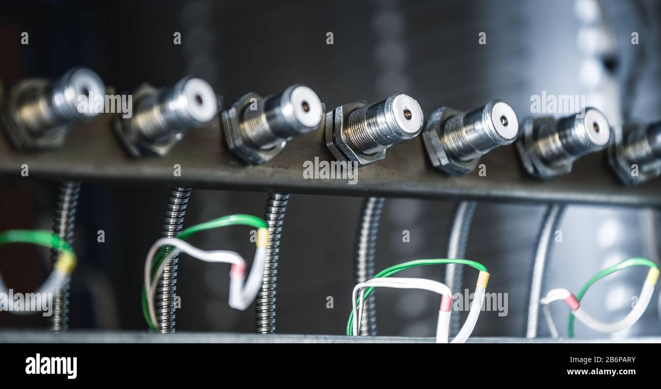 Rows of metal round plugs connected to each other by wires hang on a ...