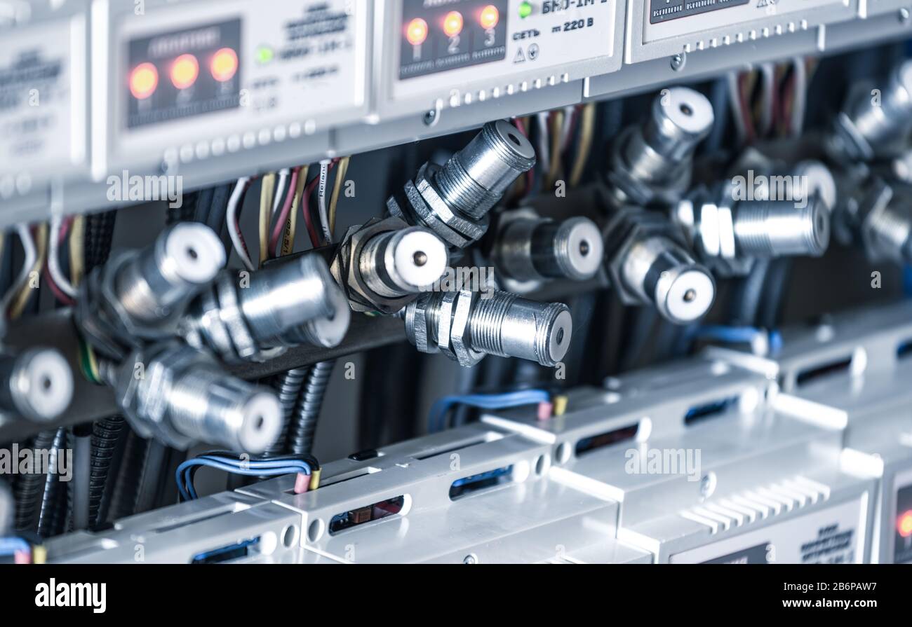 Close-up numerous metal plugs hang next to instrument panels at a ...