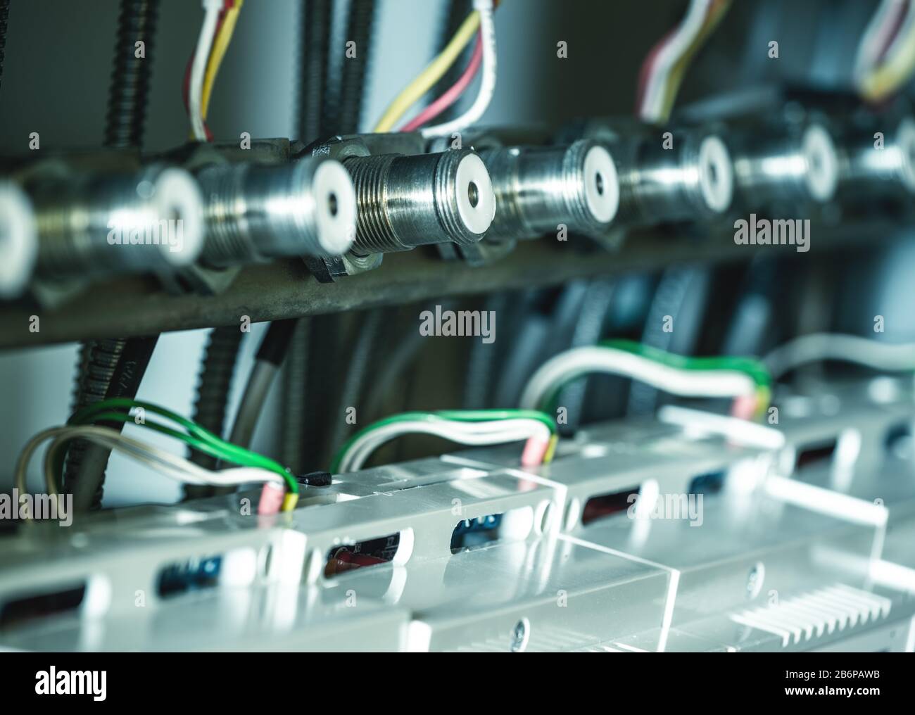 Rows of metal round plugs connected to each other by wires hang on a ...