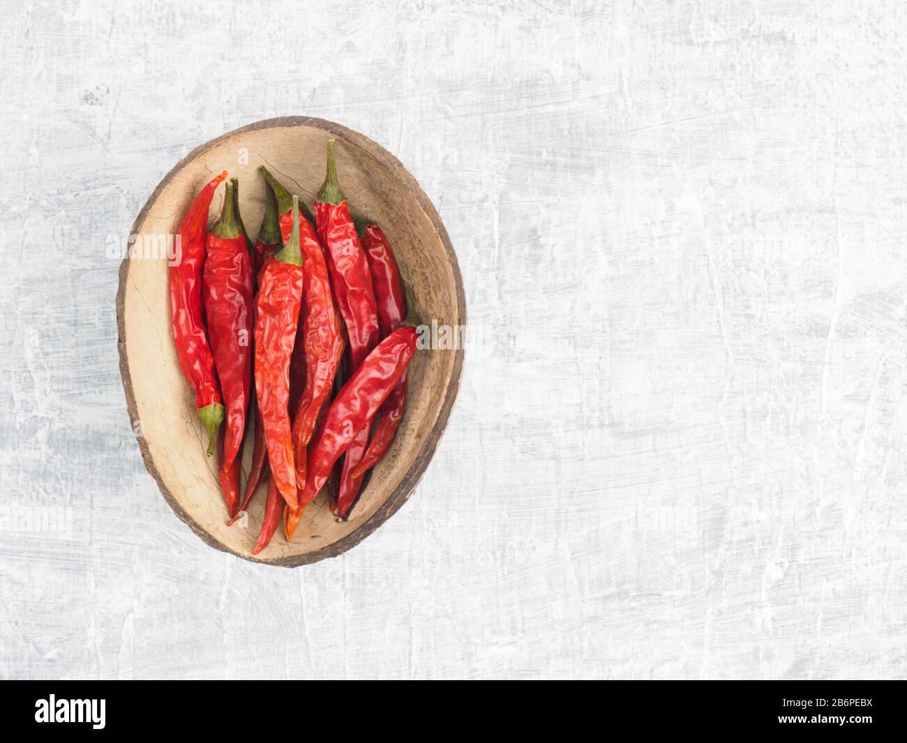 Spice pods of red chili peppers in shells from coconut on a white ...