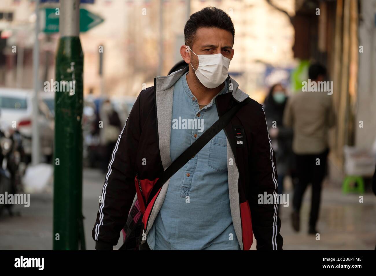 A street in Tehran and a man wearing a face mask to protect himself and ...