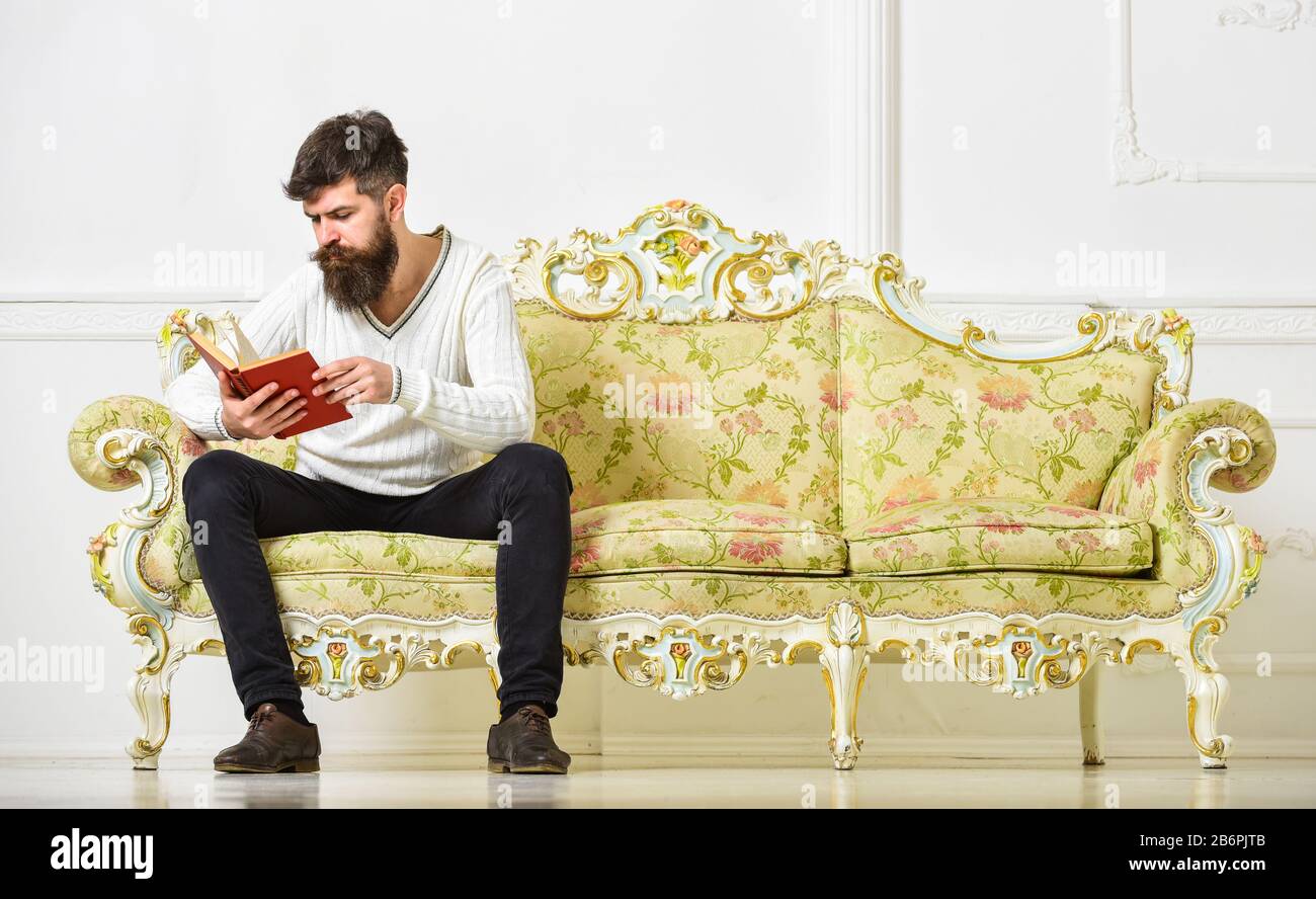 Self education concept. Man with beard and mustache sits on baroque ...