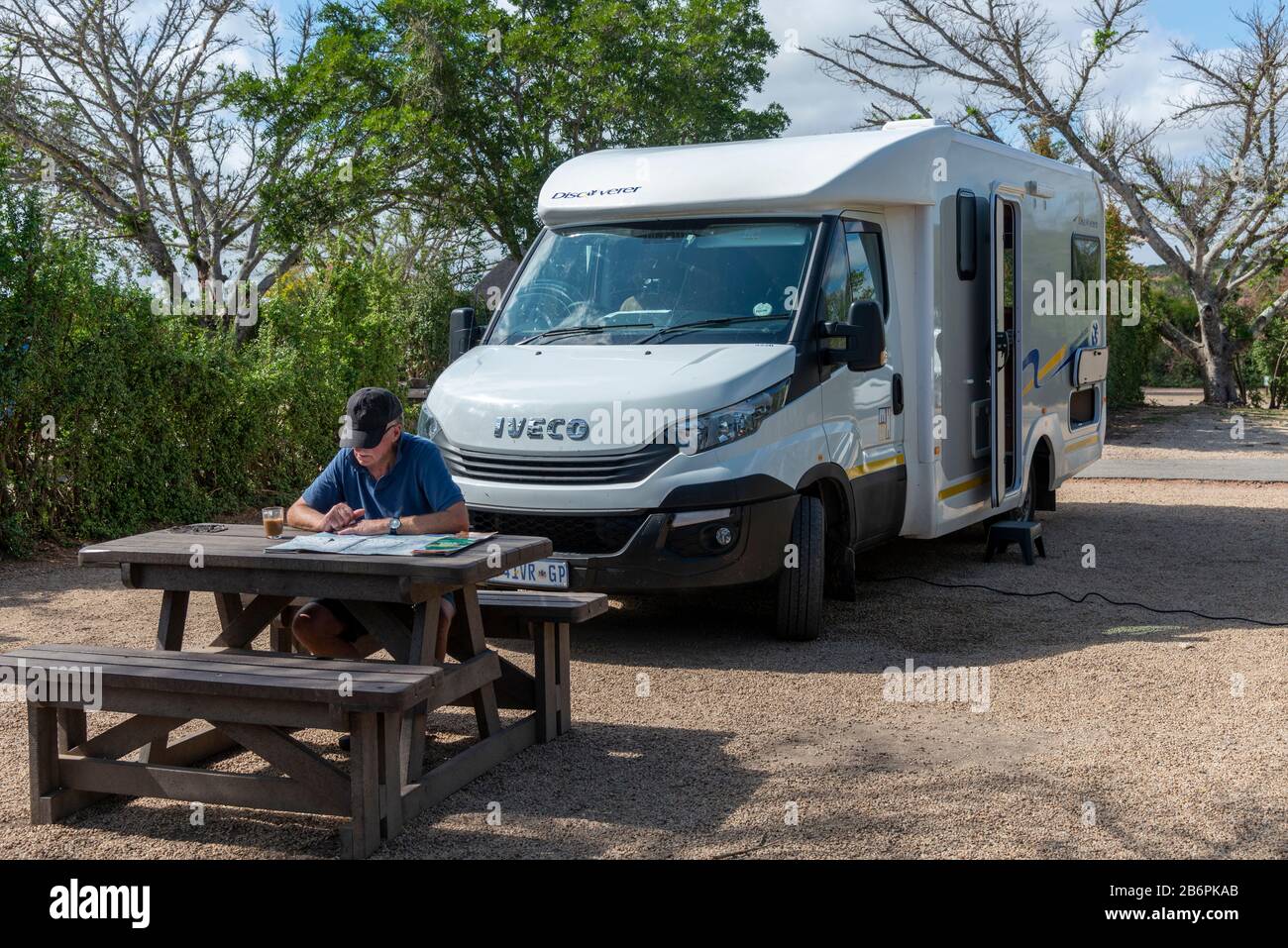 Tourist travelling by motorhome studying map on his private site at the ...