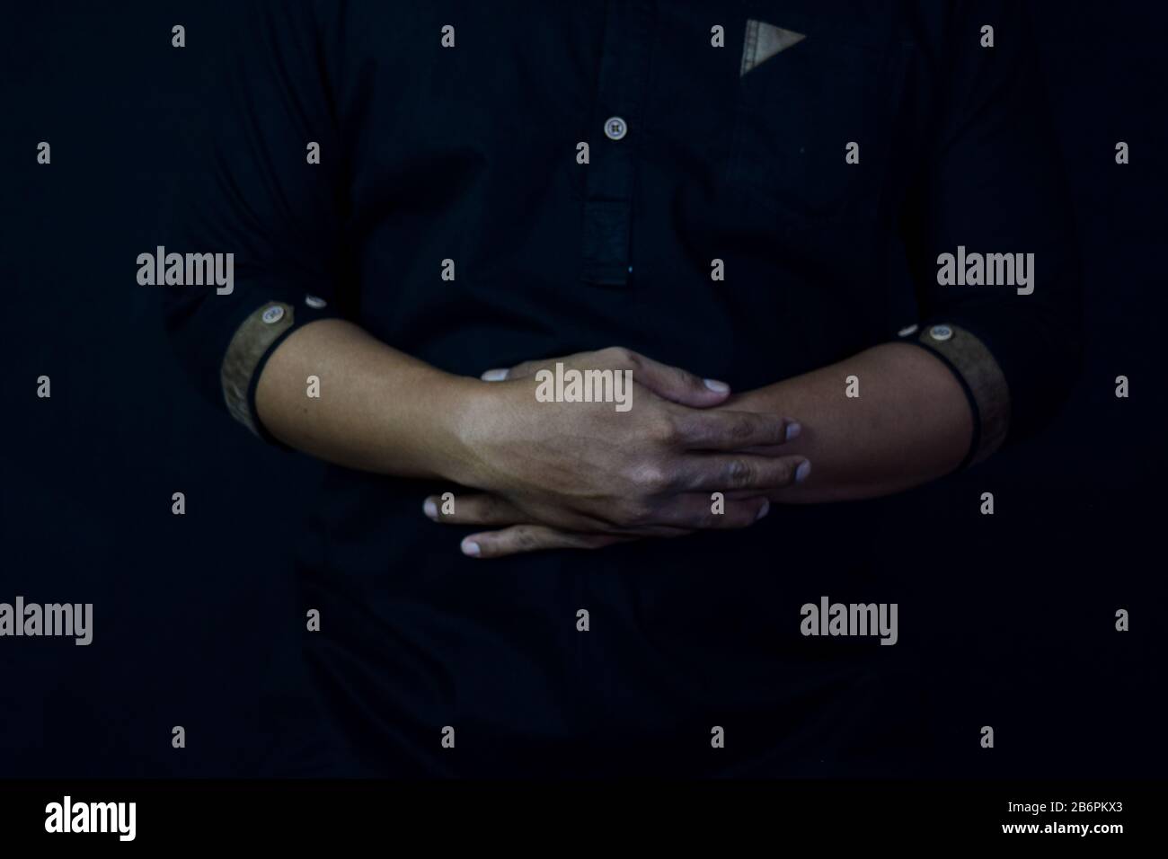 Young man praying with arms across posture. Islamic praying concept on ...