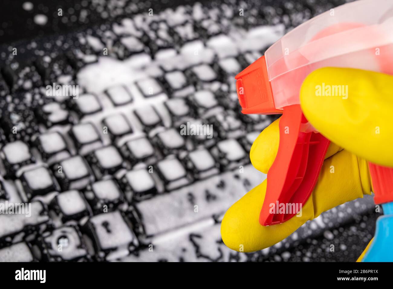 Cleaning the keyboard from dust and dirt with disinfectant. Maintenance ...