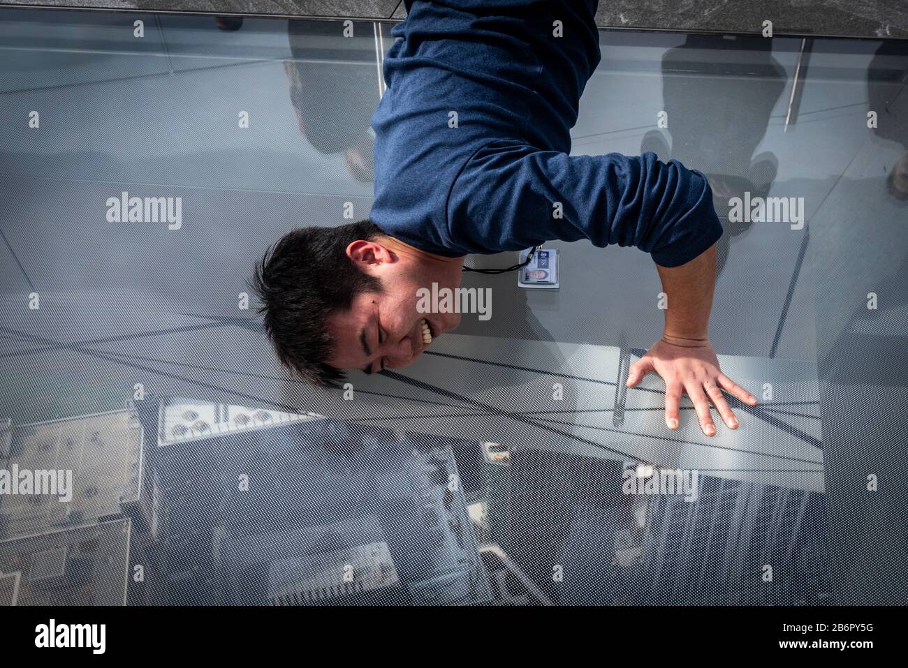 Guests pose on the thrilling glass-floor of "Edge" - the highest ...