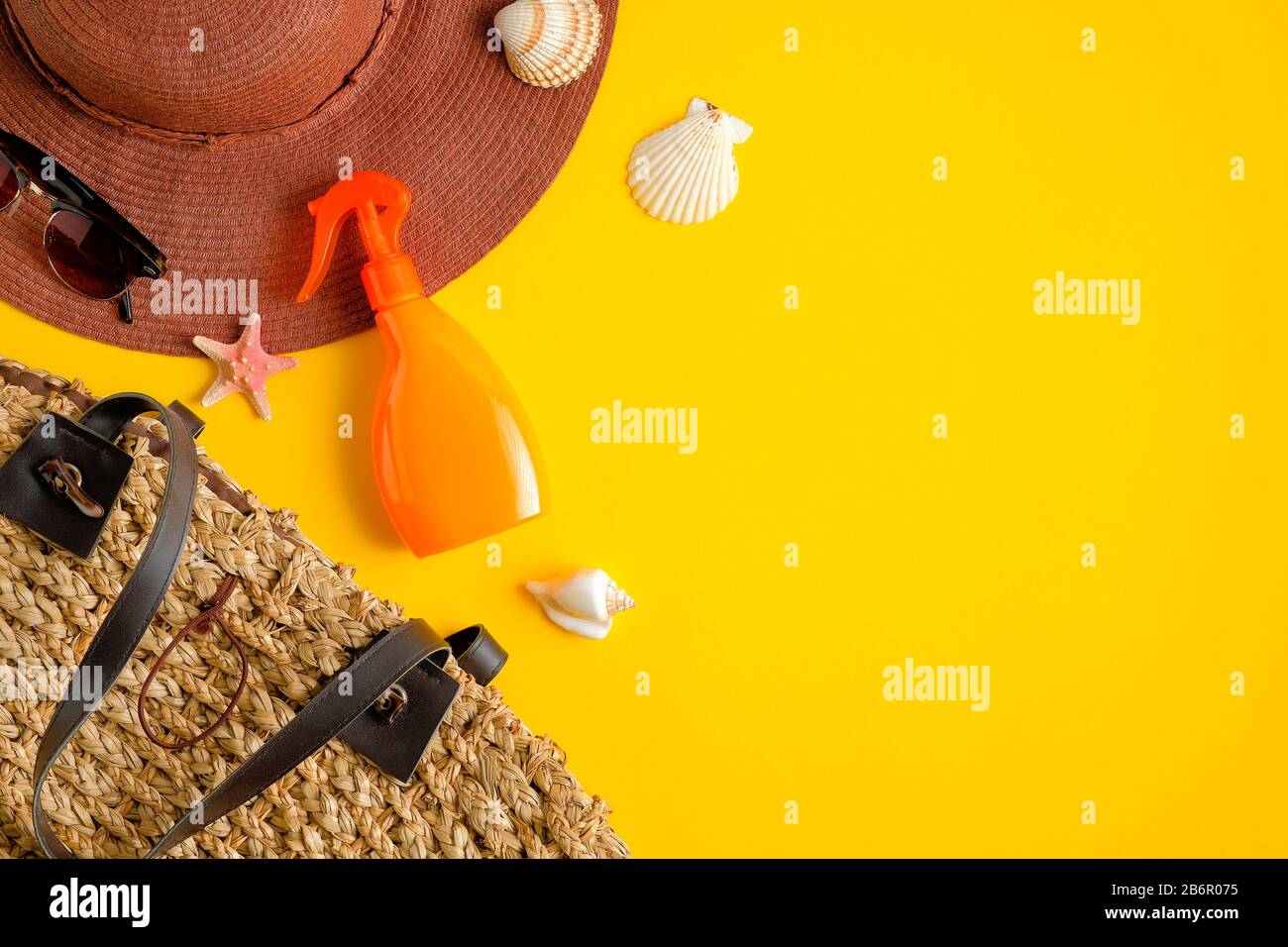 Sunscreen spray lotion in orange plastic bottle, sunglasses, beach hat ...