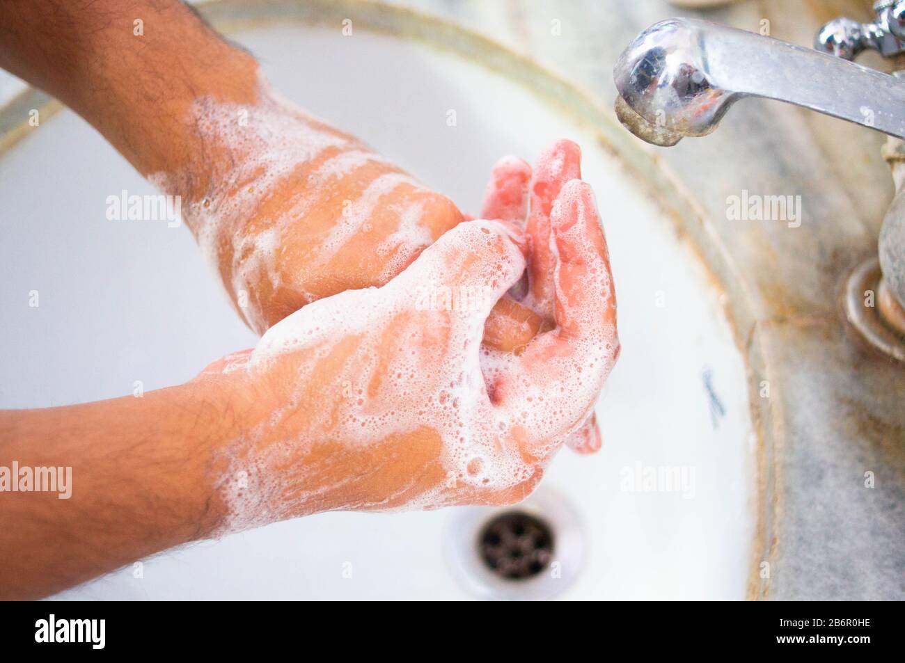 Indian person washing hands in a white coloured sink Stock Photo - Alamy