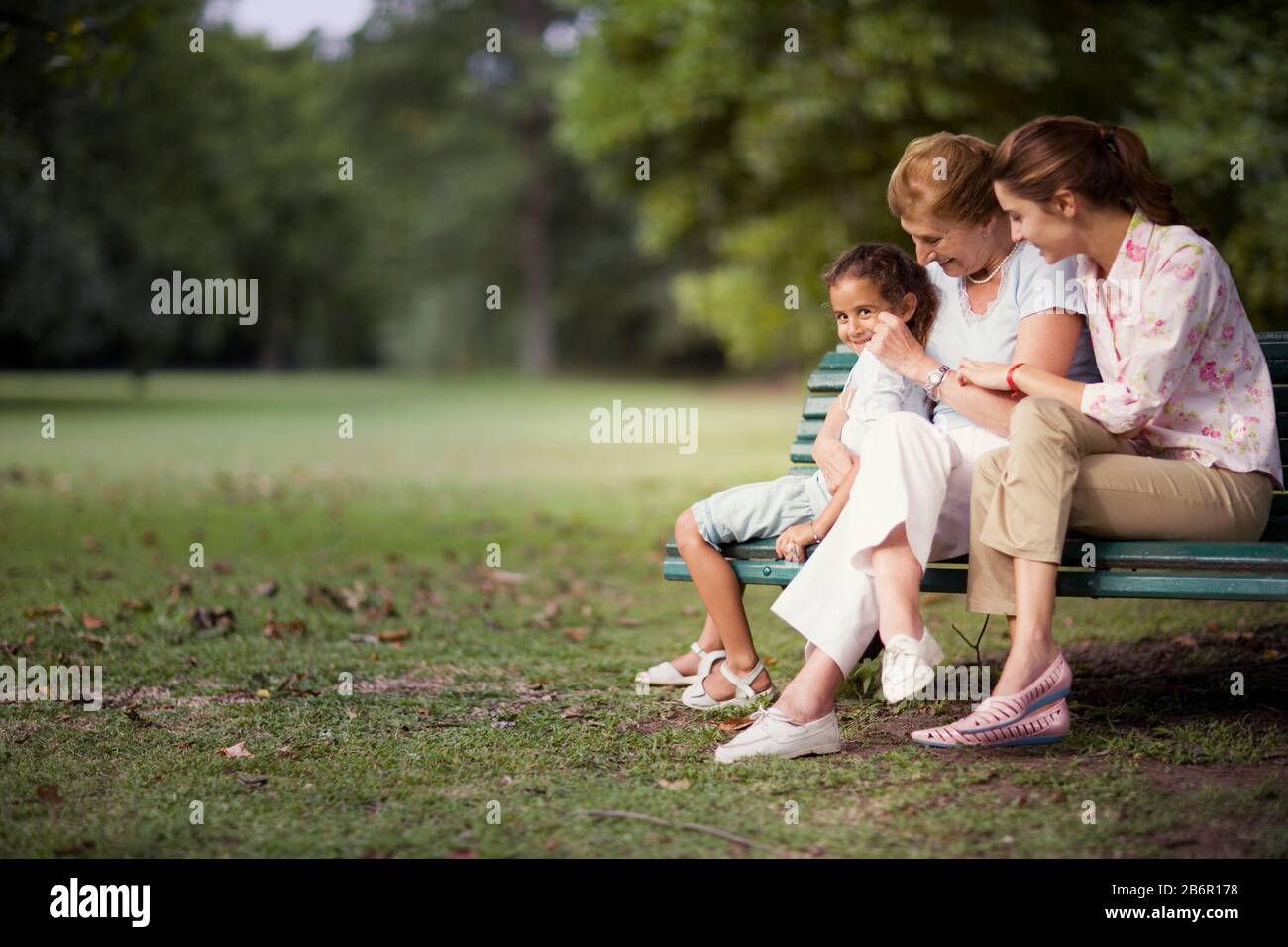 A family seen seated together on a bench Stock Photo - Alamy