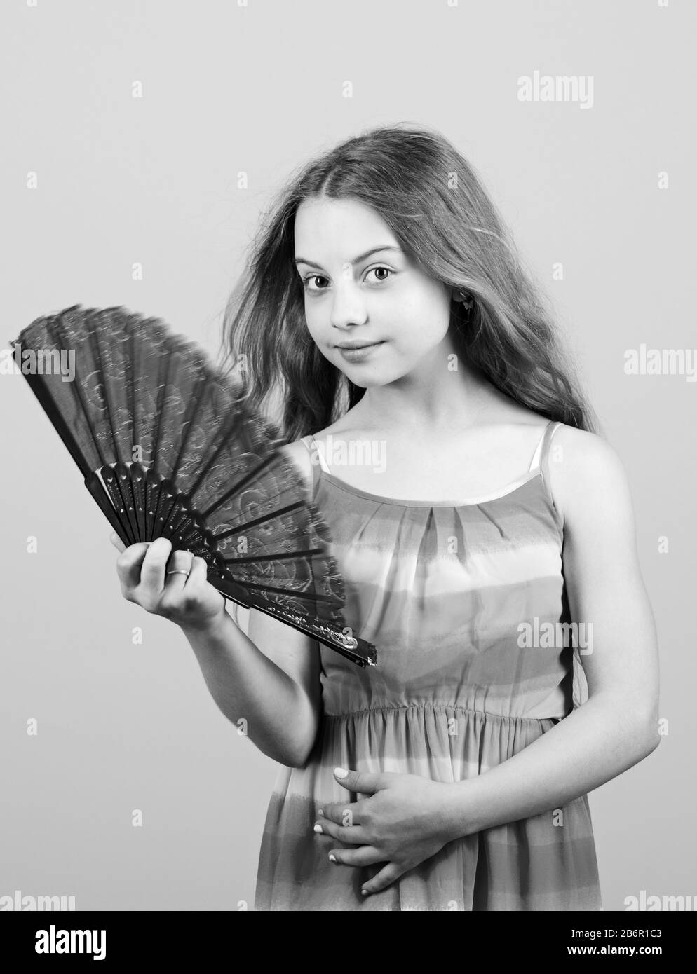 Summer heat. Fresh air. Kid girl fanning herself with fan. Cooling and ...