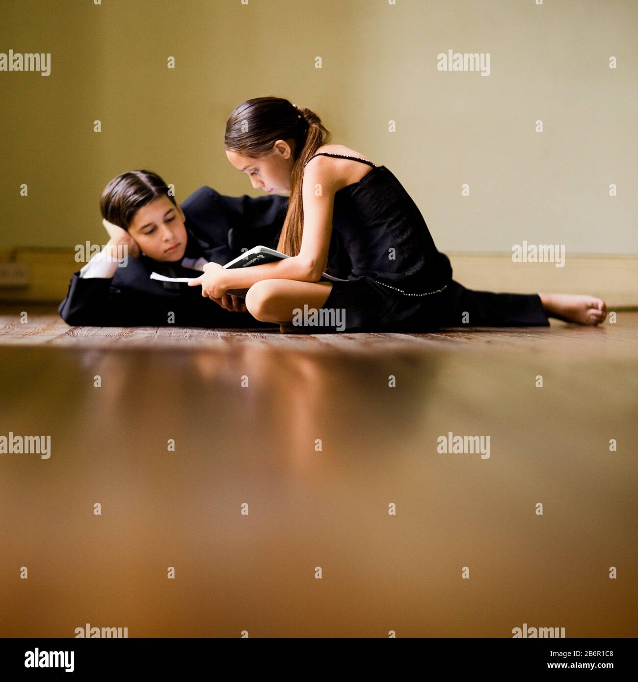Side view of little children engrossed in reading a book Stock Photo ...