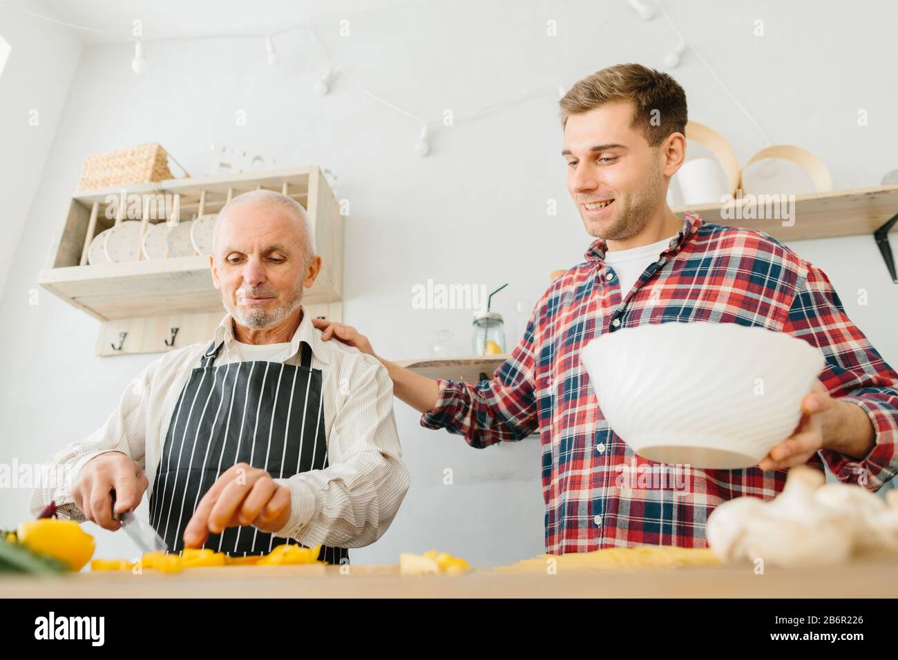 Young man and his father cooking in kitchen Stock Photo - Alamy