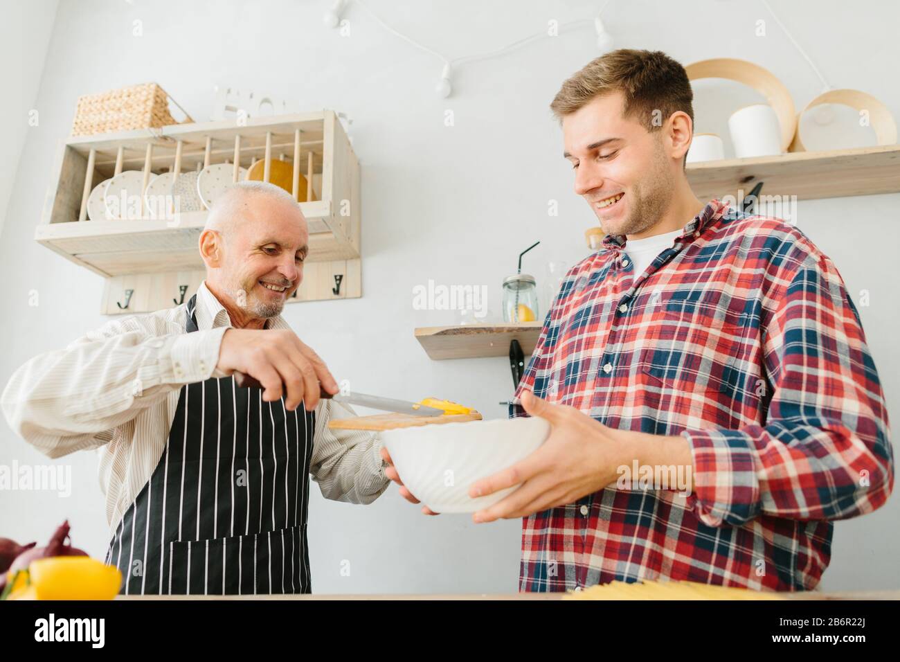 Young man and his father cooking in kitchen Stock Photo - Alamy