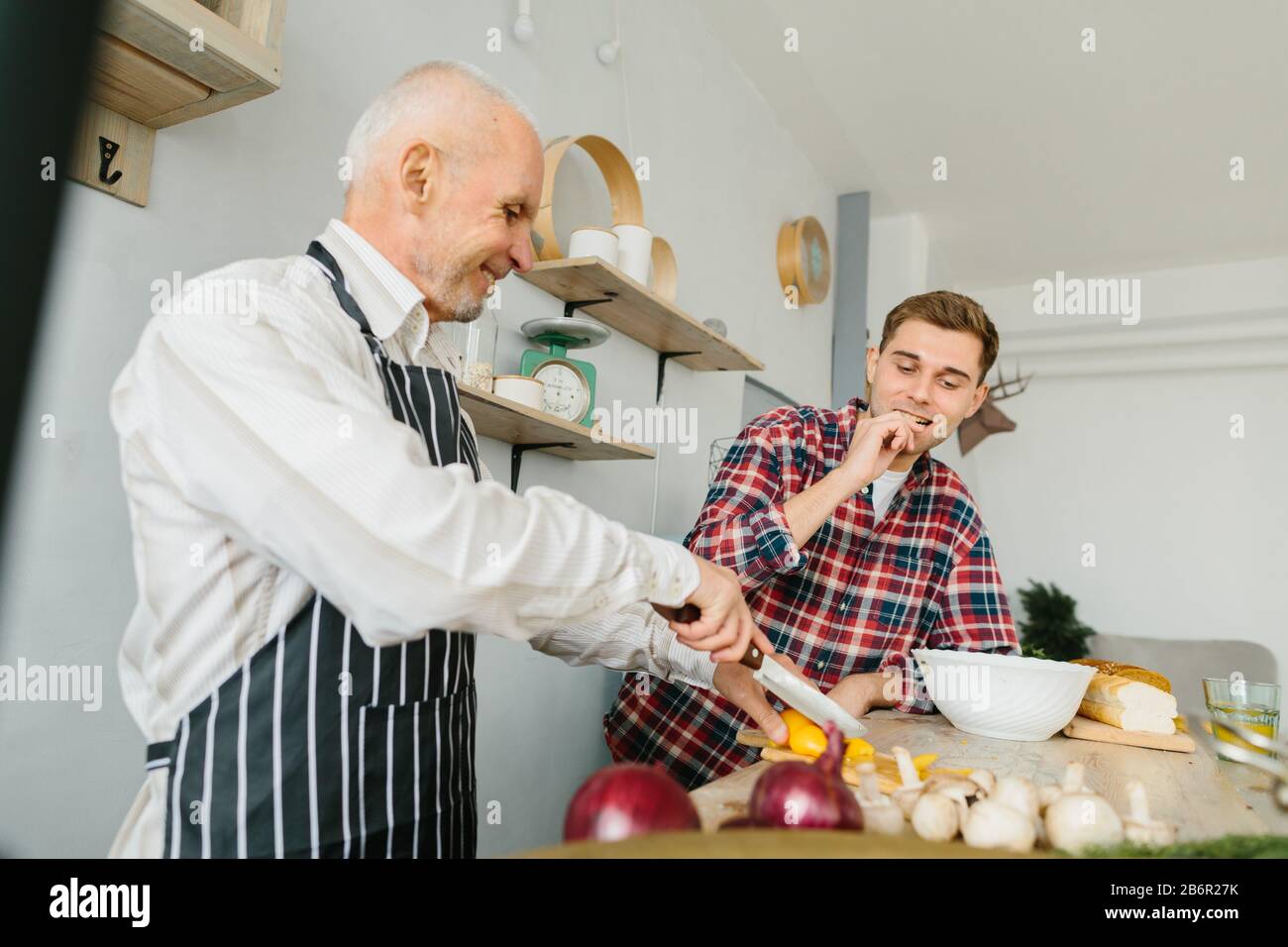 Young man and his father cooking in kitchen Stock Photo - Alamy
