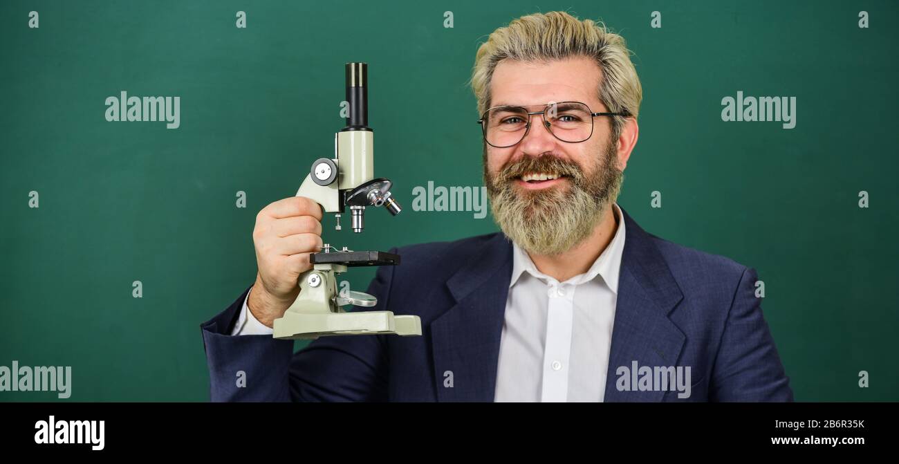 Facilitate academic progress. School teacher looking microscope ...