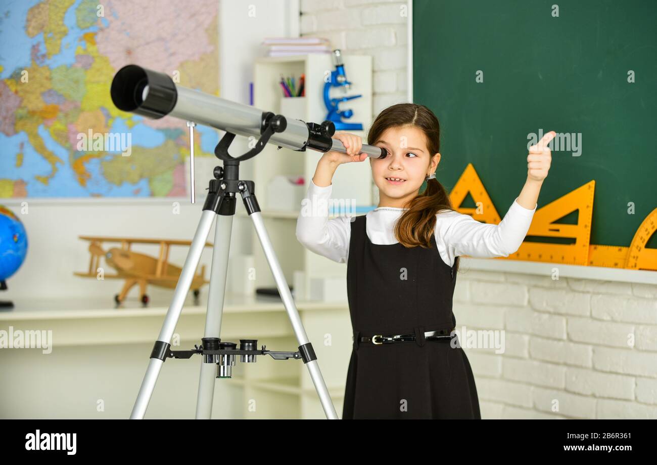 teachers day. Little girl using telescope. Telescope on tripod. School ...