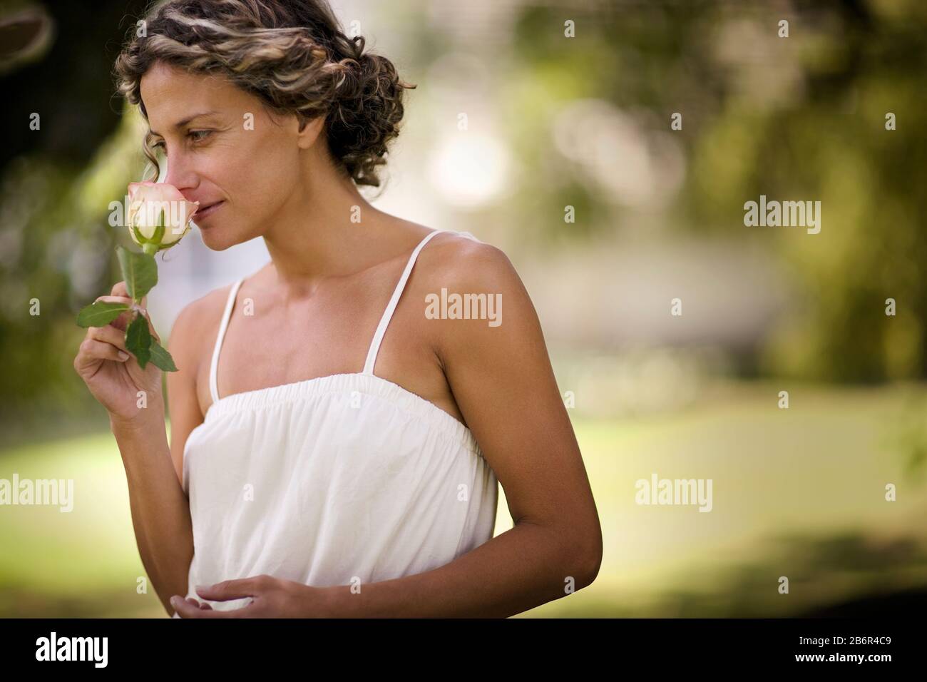 Woman smelling rose outside hi-res stock photography and images - Alamy