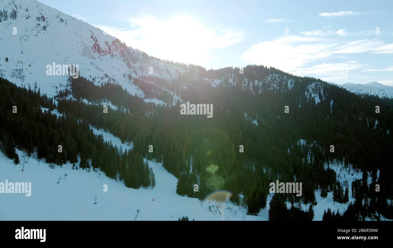 Aerial winter scene of alpine snowy mountain peaks and dark spruce ...