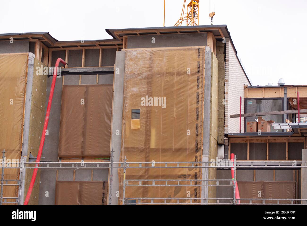 New low-rise residential building under construction wth red pipes ...