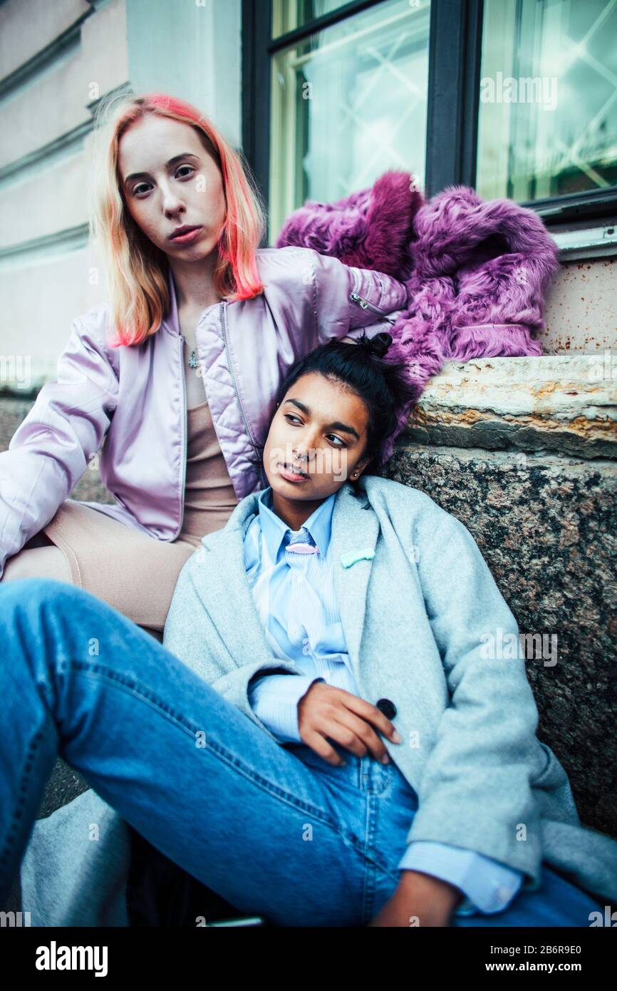 Two teenage girls infront of university building smiling, having fun ...