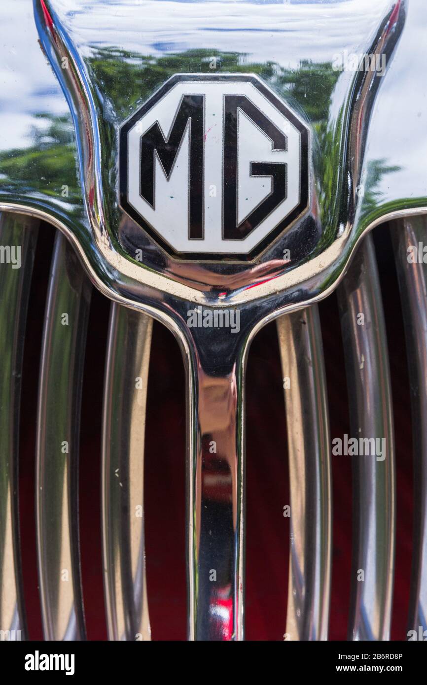 Detail of shiny chrome radiator grille and MG badge on classic British ...