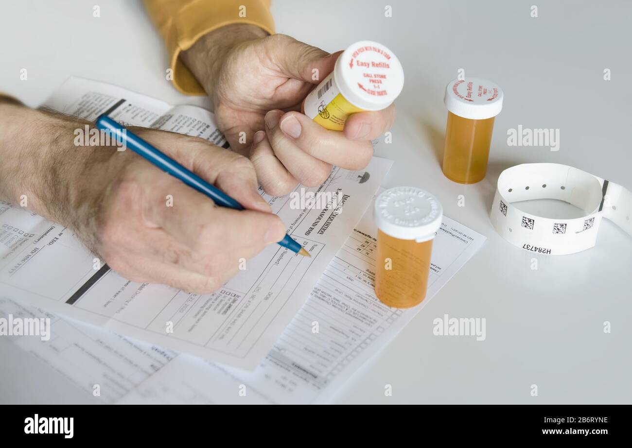 The doctor is writing and checking different pill containers Stock ...