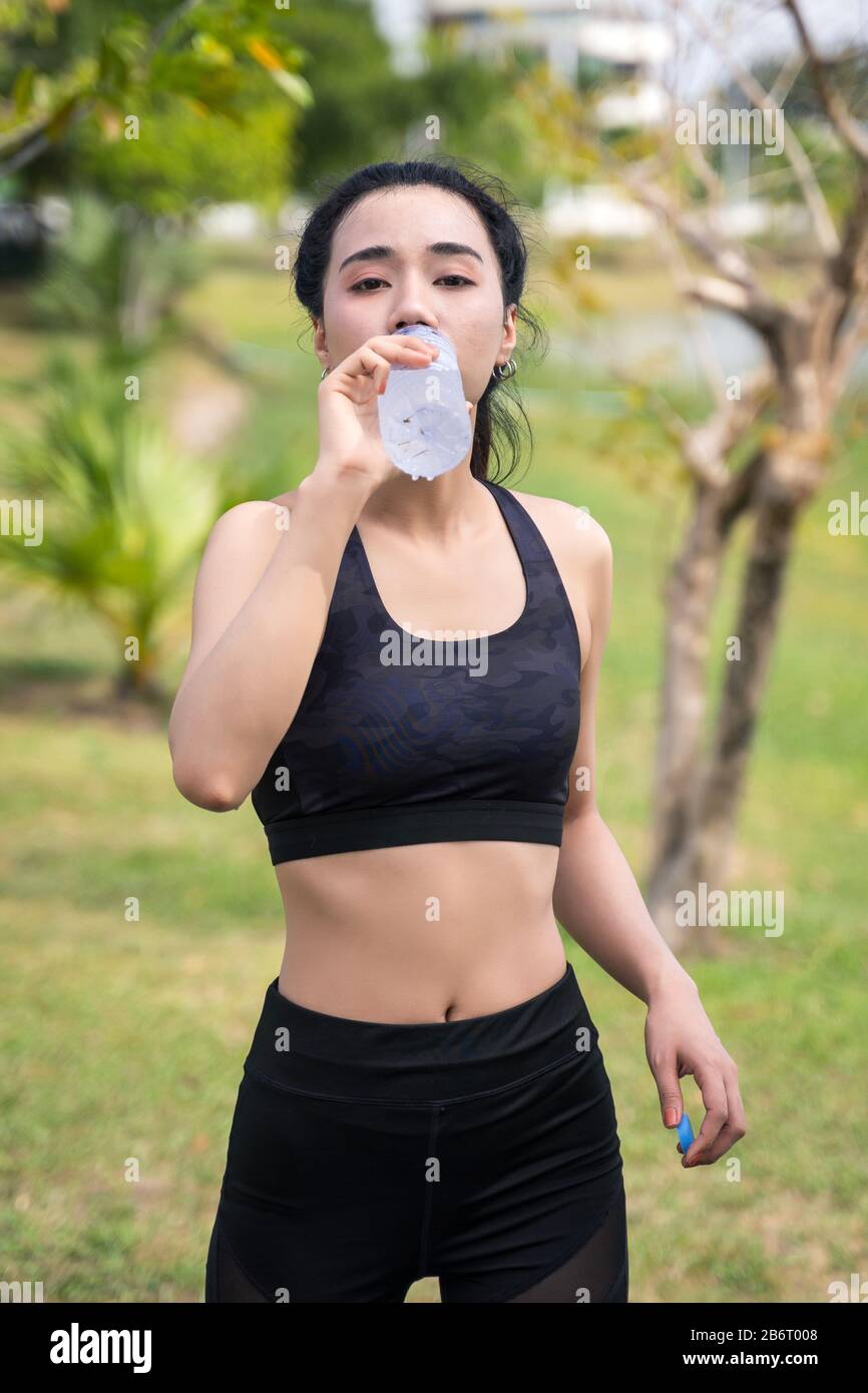 Young woman runner wear white sporty vest, white cap, black short pant ...