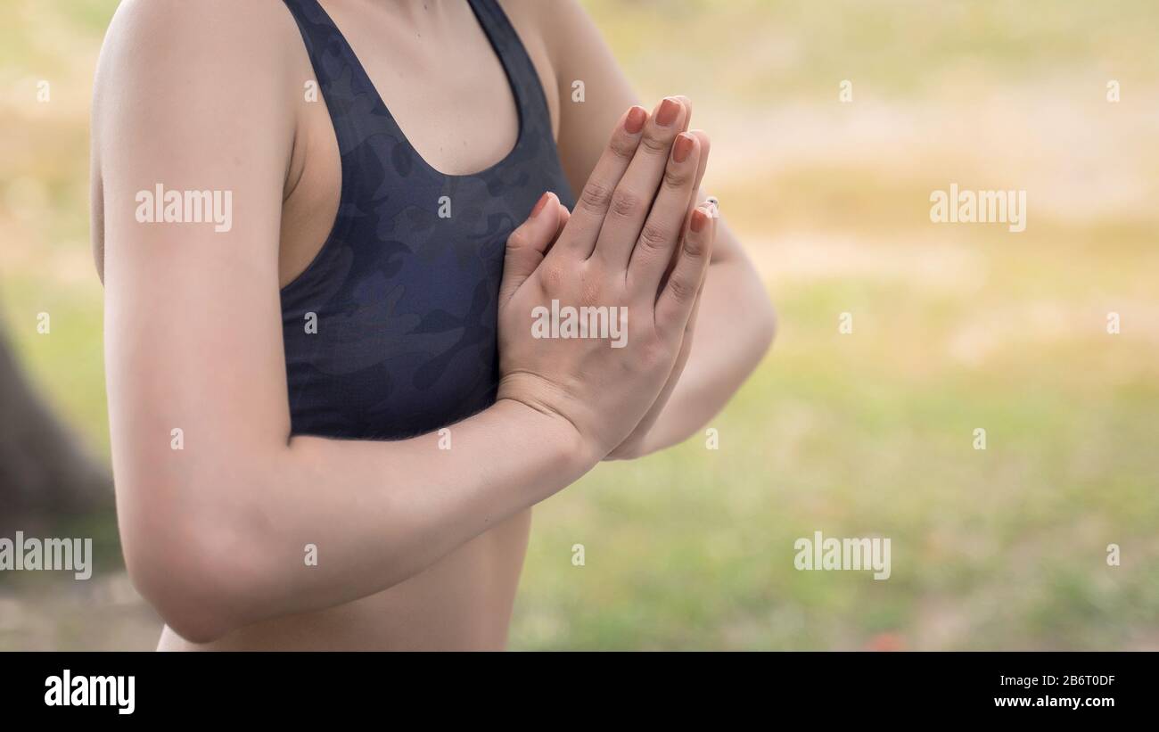 Slim beautiful women practices yoga poses on the mat beside a lake at ...