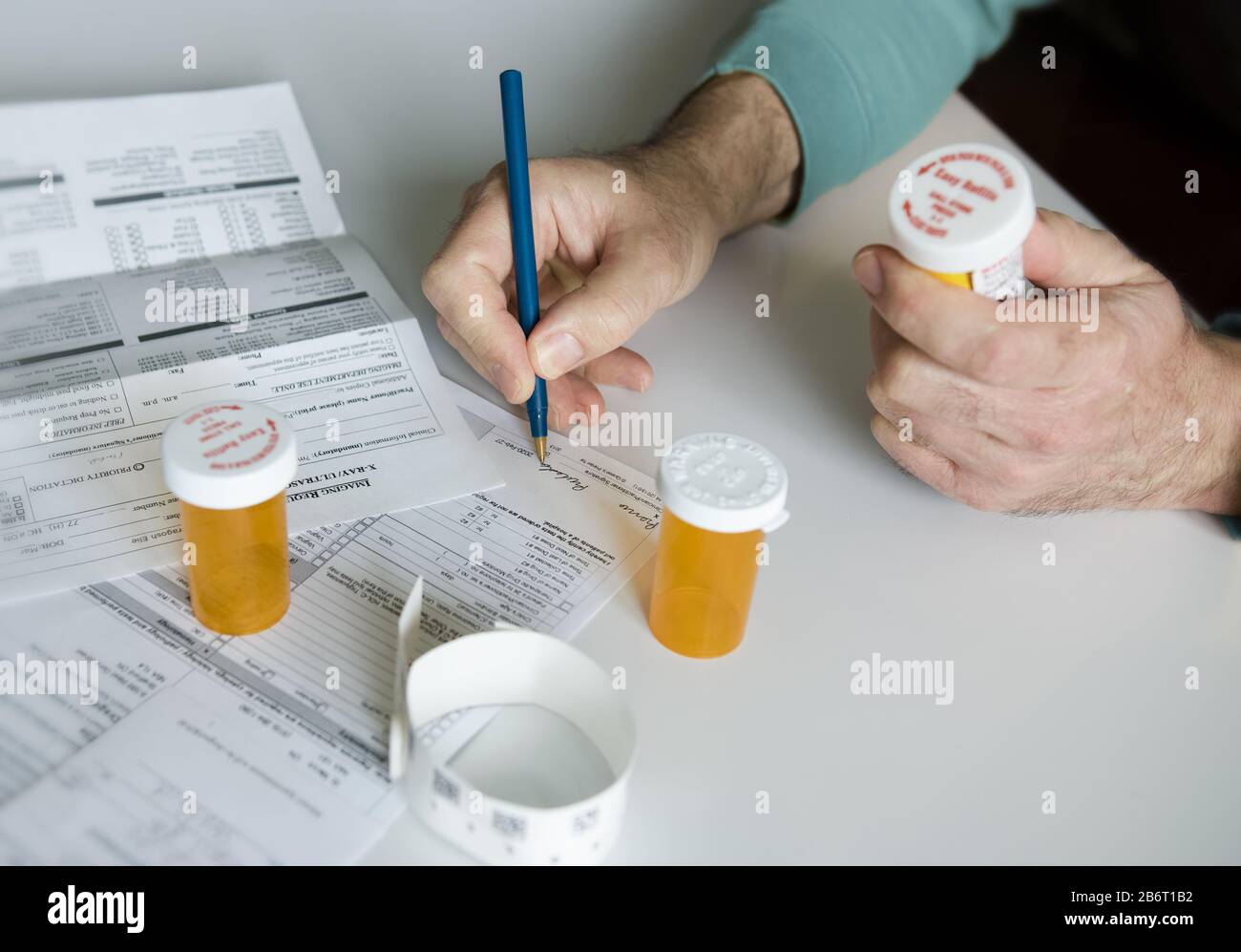 The doctor is writing and checking different pill containers Stock ...