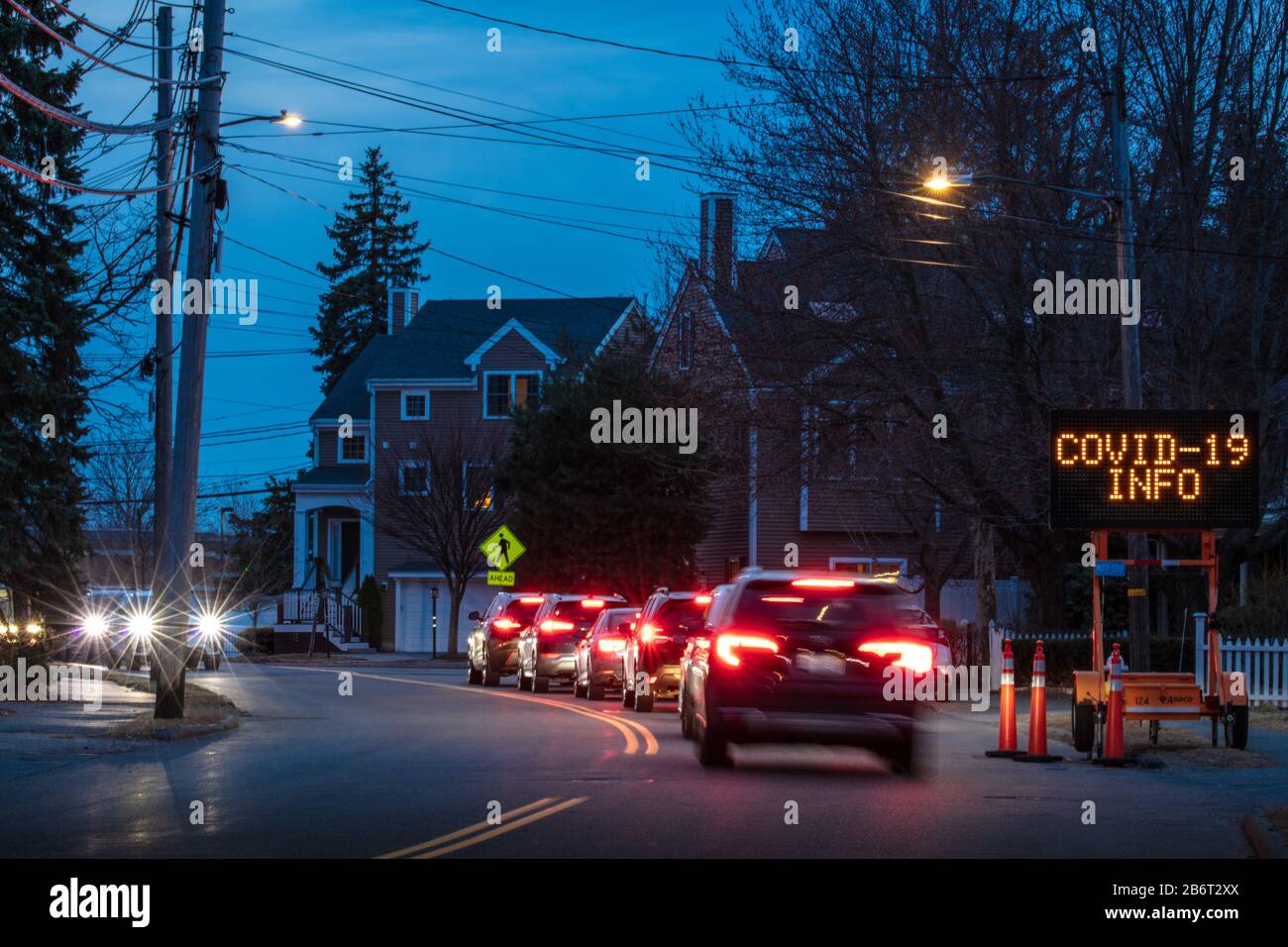 Flashing emergency road sign with COVID-19 info and automobile traffic ...