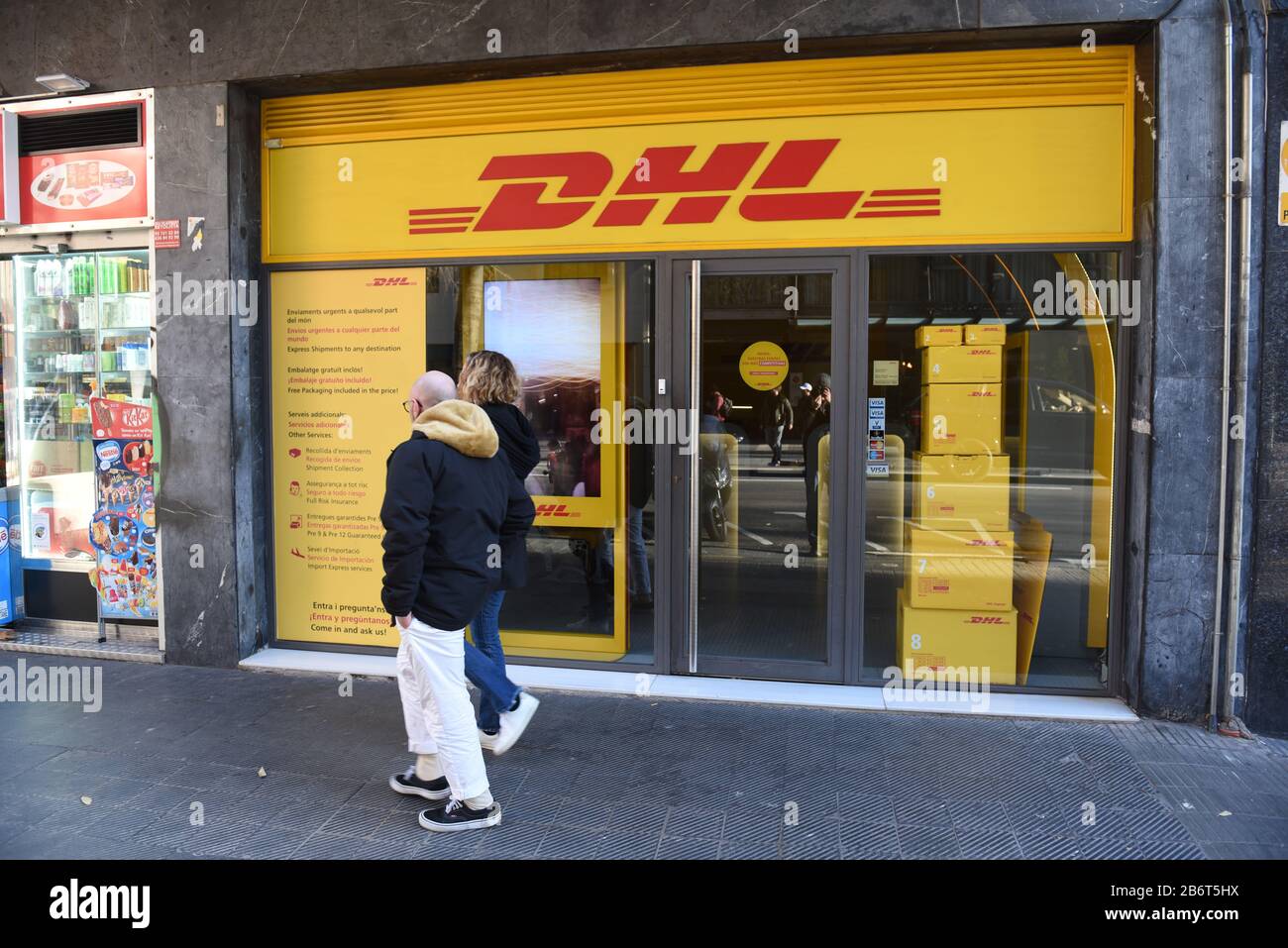 People walk past a DHL shop Stock Photo - Alamy